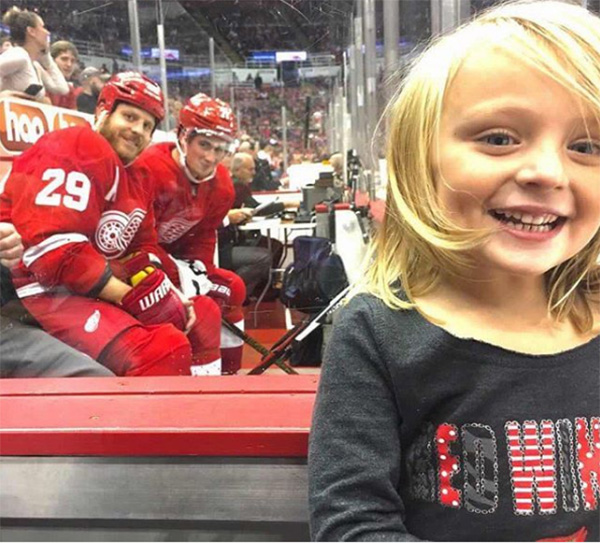 Hockey players smile in penalty box for little girls photo